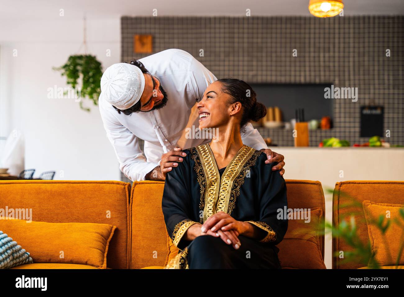 Happy beautiful young arab couple with emirati clothing together at home - Middle-eastern man ...