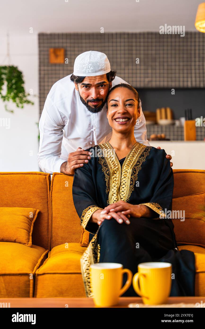 Happy beautiful young arab couple with emirati clothing together at home - Middle-eastern man ...