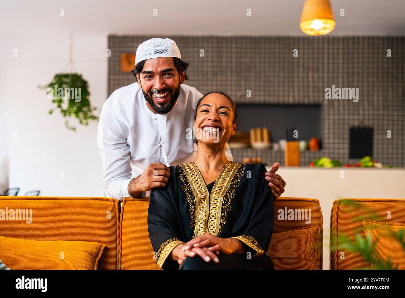 Happy beautiful young arab couple with emirati clothing together at home - Middle-eastern man ...