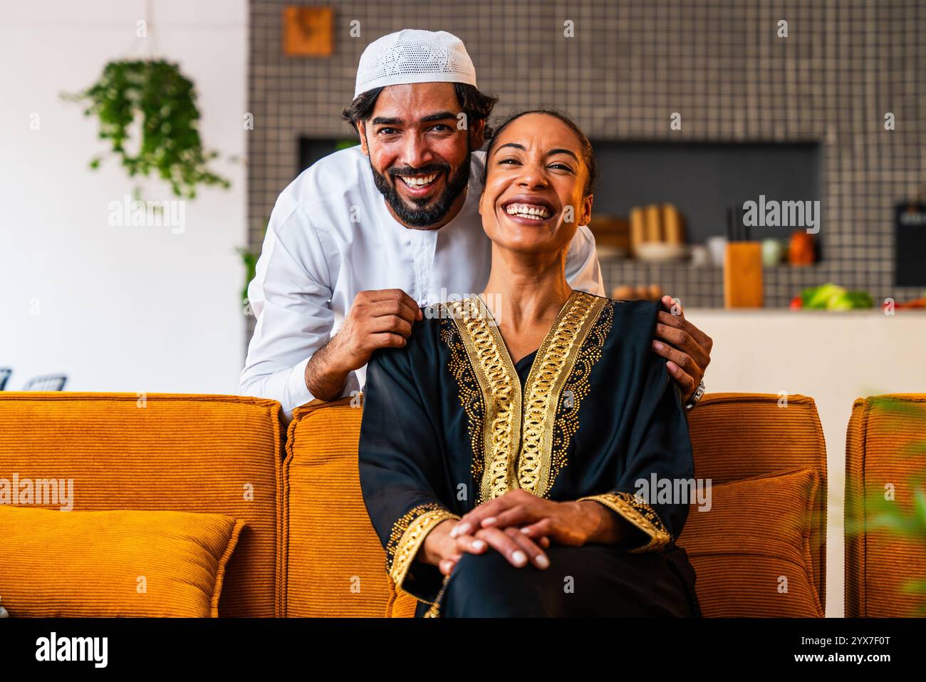 Happy beautiful young arab couple with emirati clothing together at home - Middle-eastern man ...