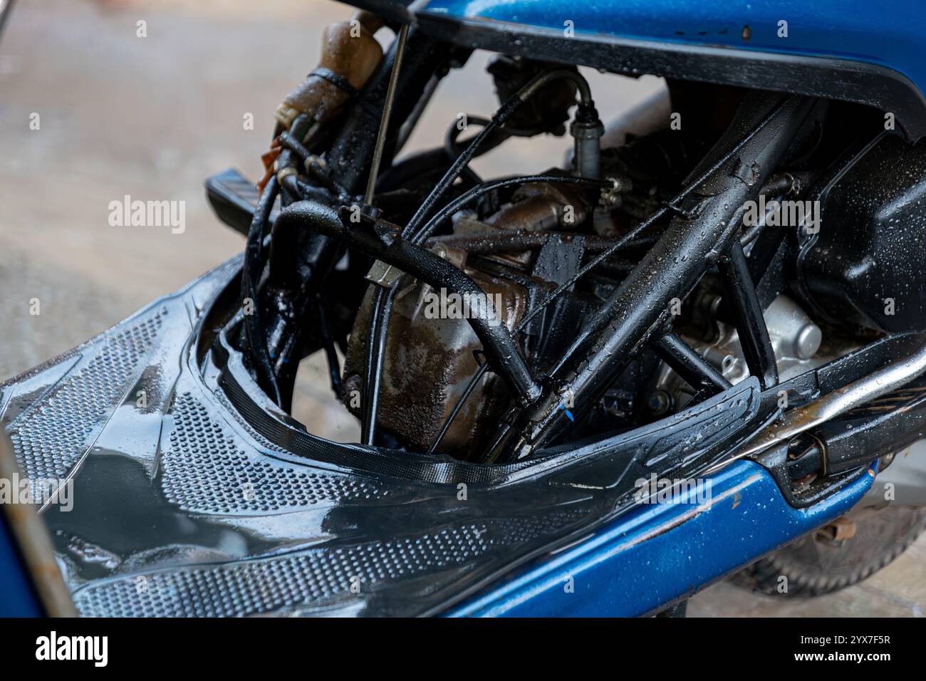 Close-up of a wet scooter engine after washing, showcasing its ...
