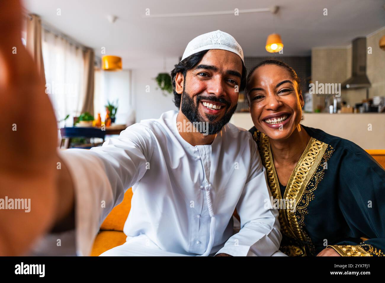 Happy beautiful young arab couple with emirati clothing together at home - Middle-eastern man ...