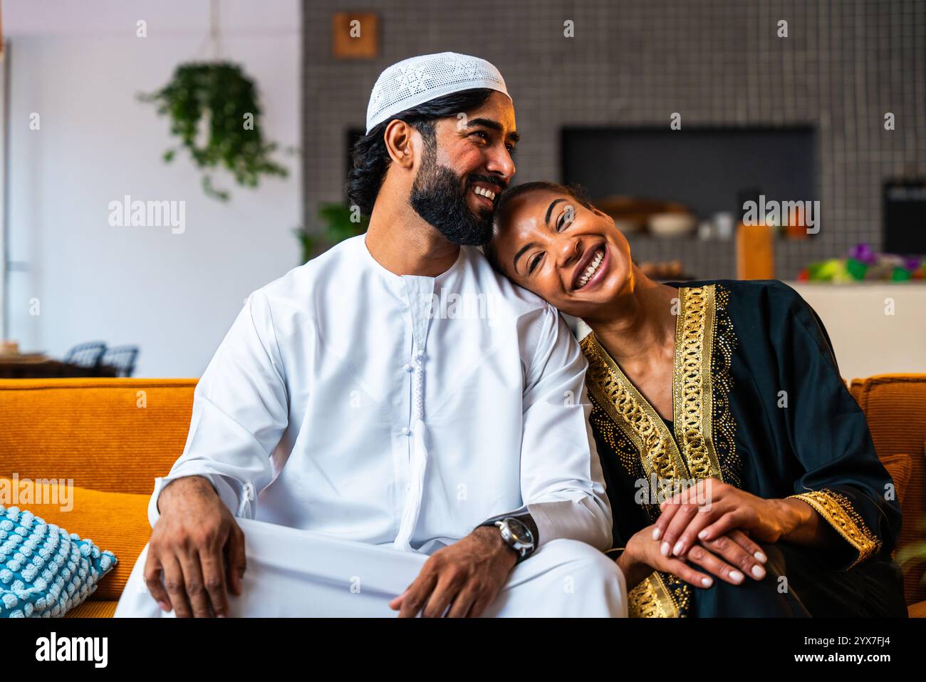 Happy beautiful young arab couple with emirati clothing together at home - Middle-eastern man ...