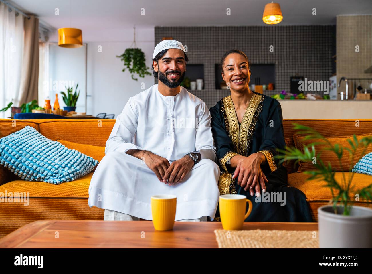 Happy beautiful young arab couple with emirati clothing together at home - Middle-eastern man ...