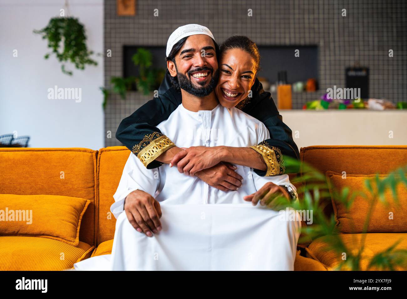 Happy beautiful young arab couple with emirati clothing together at home - Middle-eastern man ...