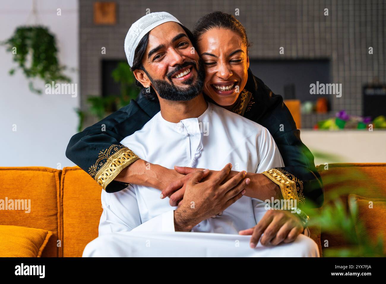 Happy beautiful young arab couple with emirati clothing together at home - Middle-eastern man ...