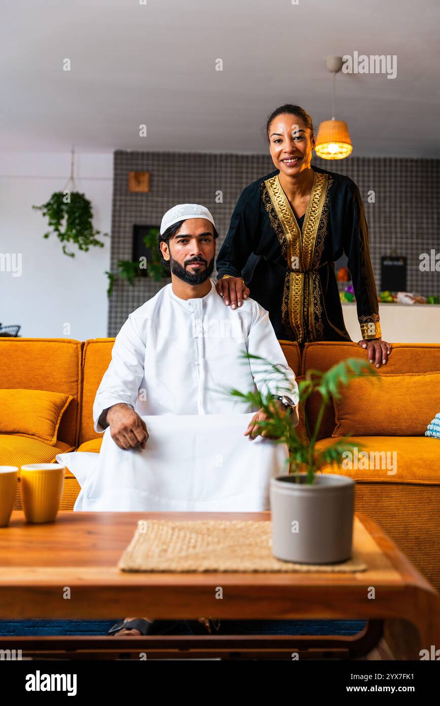 Happy beautiful young arab couple with emirati clothing together at home - Middle-eastern man ...