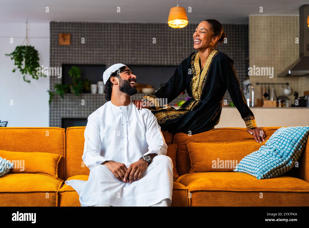 Happy beautiful young arab couple with emirati clothing together at home - Middle-eastern man ...