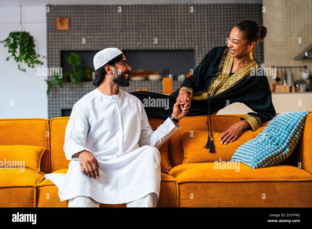 Happy beautiful young arab couple with emirati clothing together at home - Middle-eastern man ...