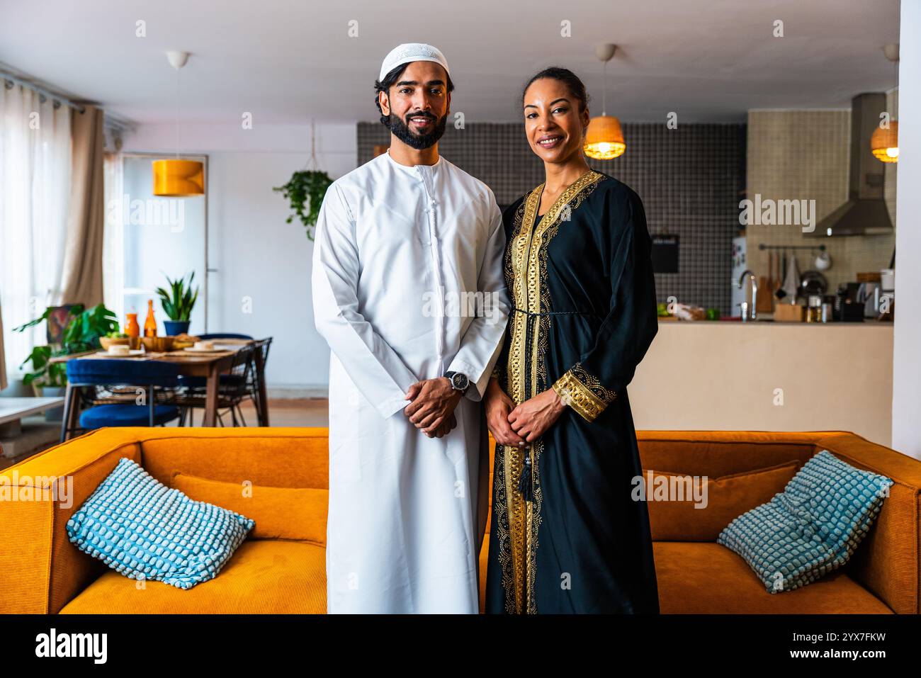 Happy beautiful young arab couple with emirati clothing together at home - Middle-eastern man ...