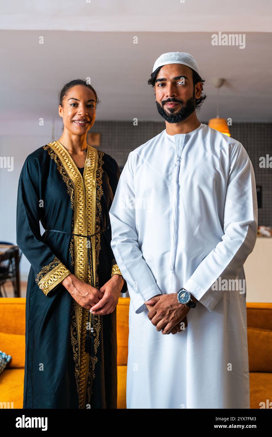 Happy beautiful young arab couple with emirati clothing together at home - Middle-eastern man ...