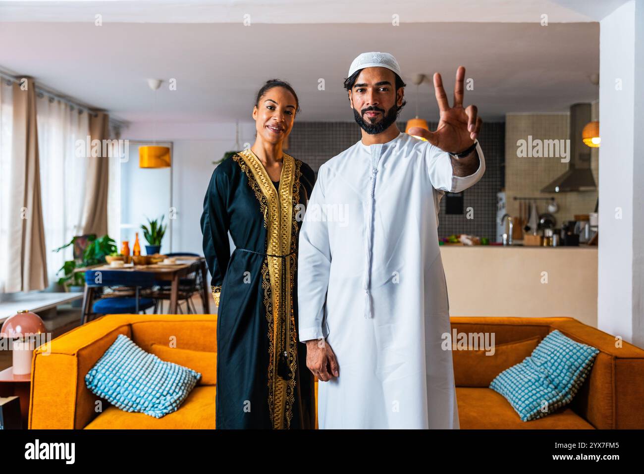 Happy beautiful young arab couple with emirati clothing together at home - Middle-eastern man ...