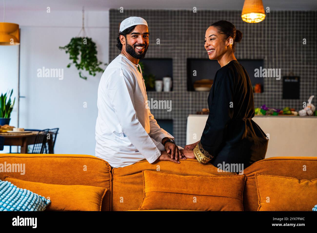 Happy beautiful young arab couple with emirati clothing together at home - Middle-eastern man ...