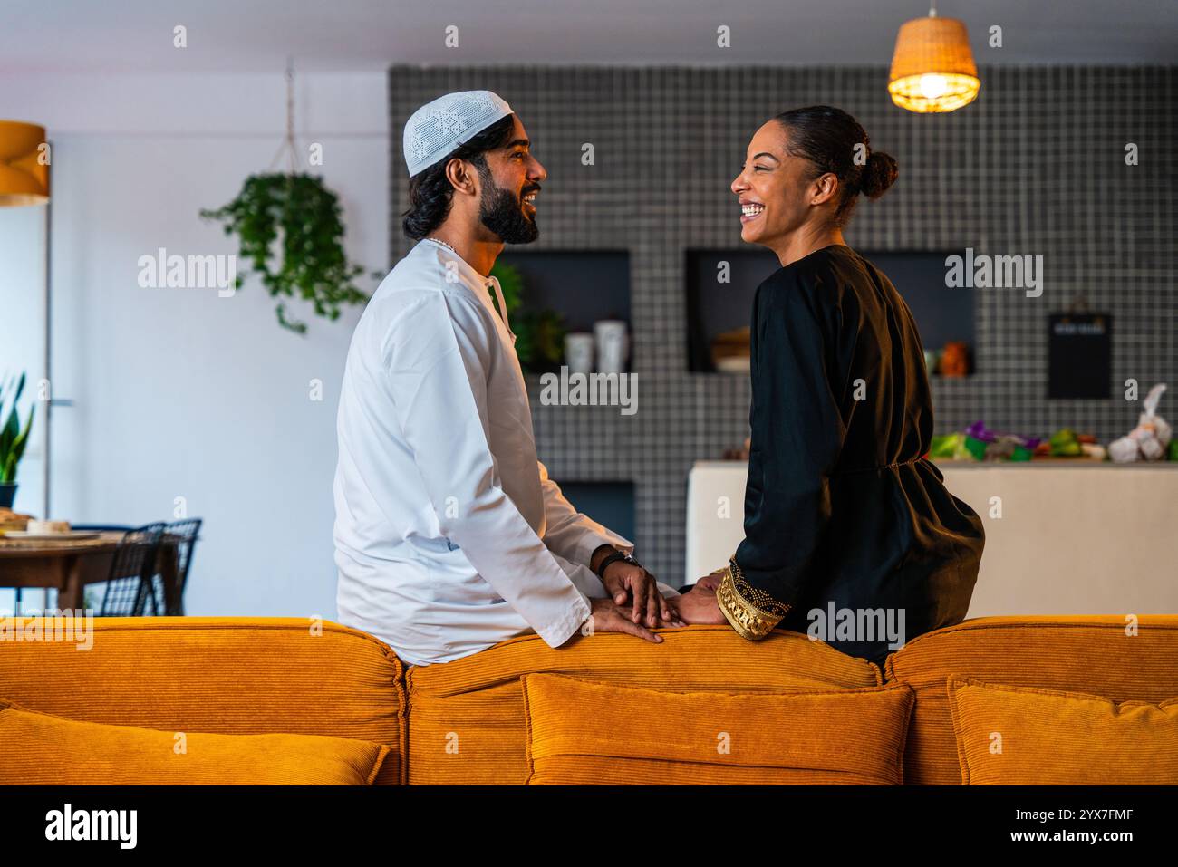 Happy beautiful young arab couple with emirati clothing together at home - Middle-eastern man ...