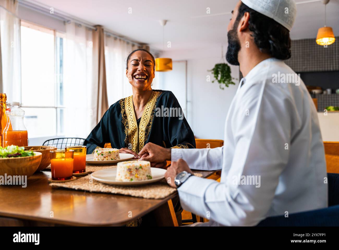 Happy beautiful young arab couple with emirati clothing having lunch ...