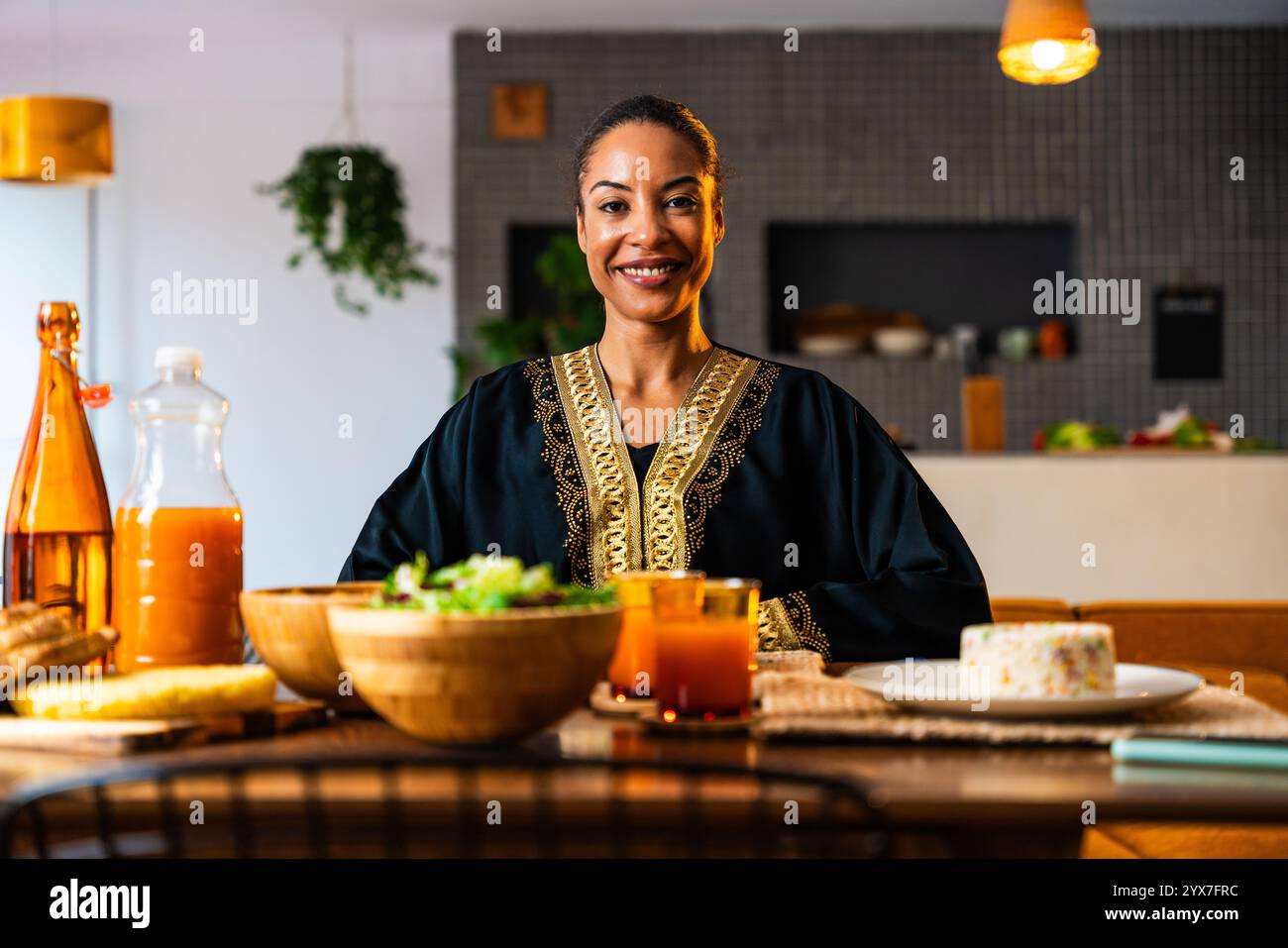 Happy beautiful young arab woman with emirati clothing having lunch at ...