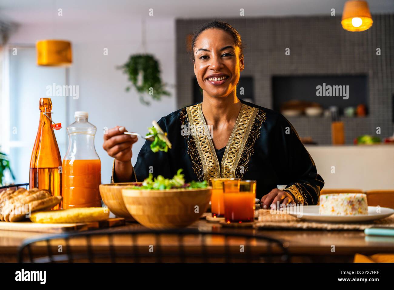 Happy beautiful young arab woman with emirati clothing having lunch at ...