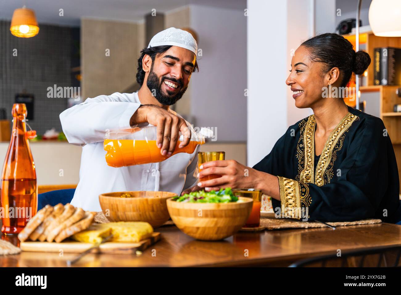 Happy beautiful young arab couple with emirati clothing having lunch ...