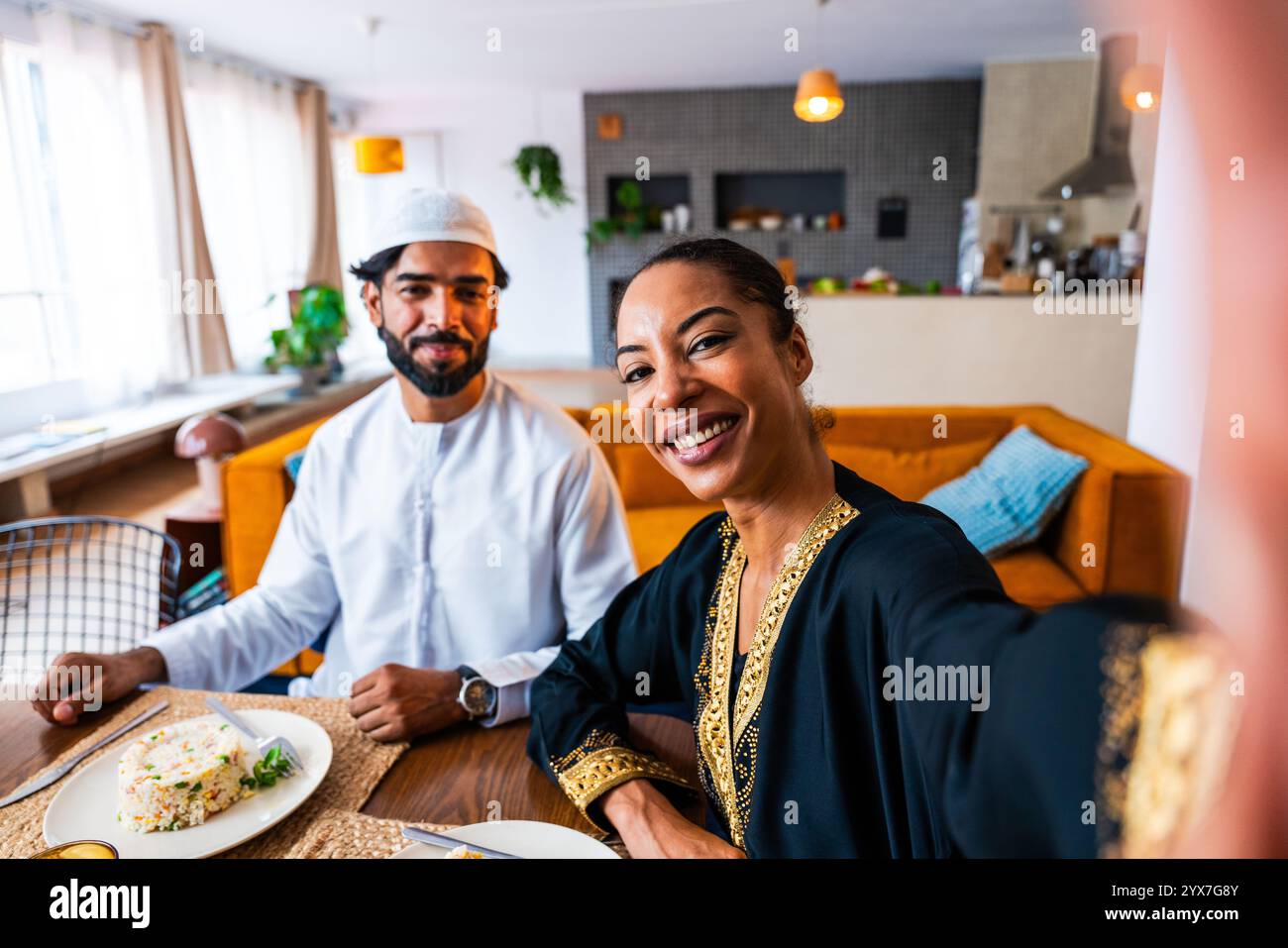 Happy beautiful young arab couple with emirati clothing having lunch ...