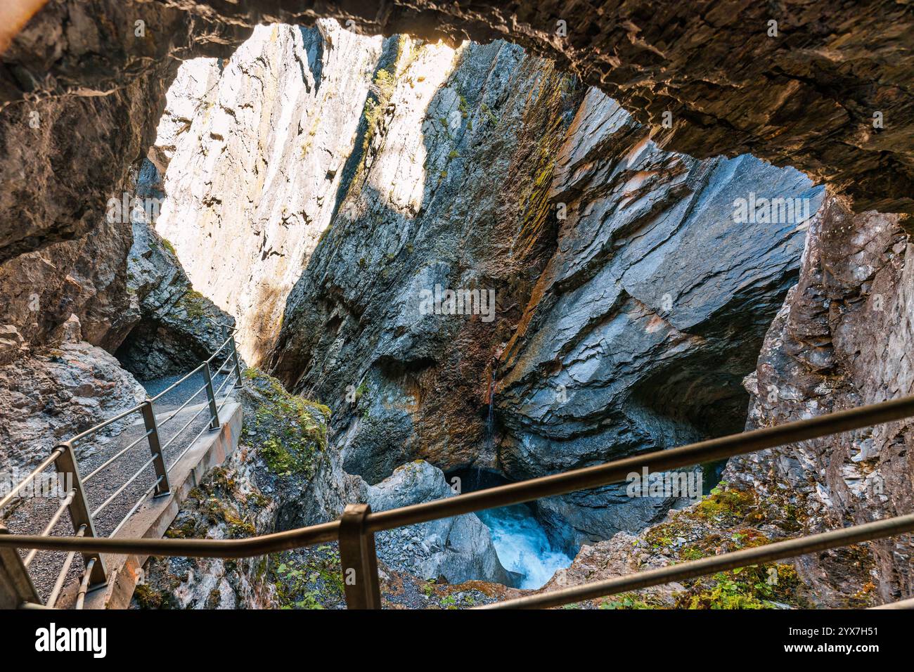 Natural limestone cave with stream flowing in Rosenlaui glacier gorge ...