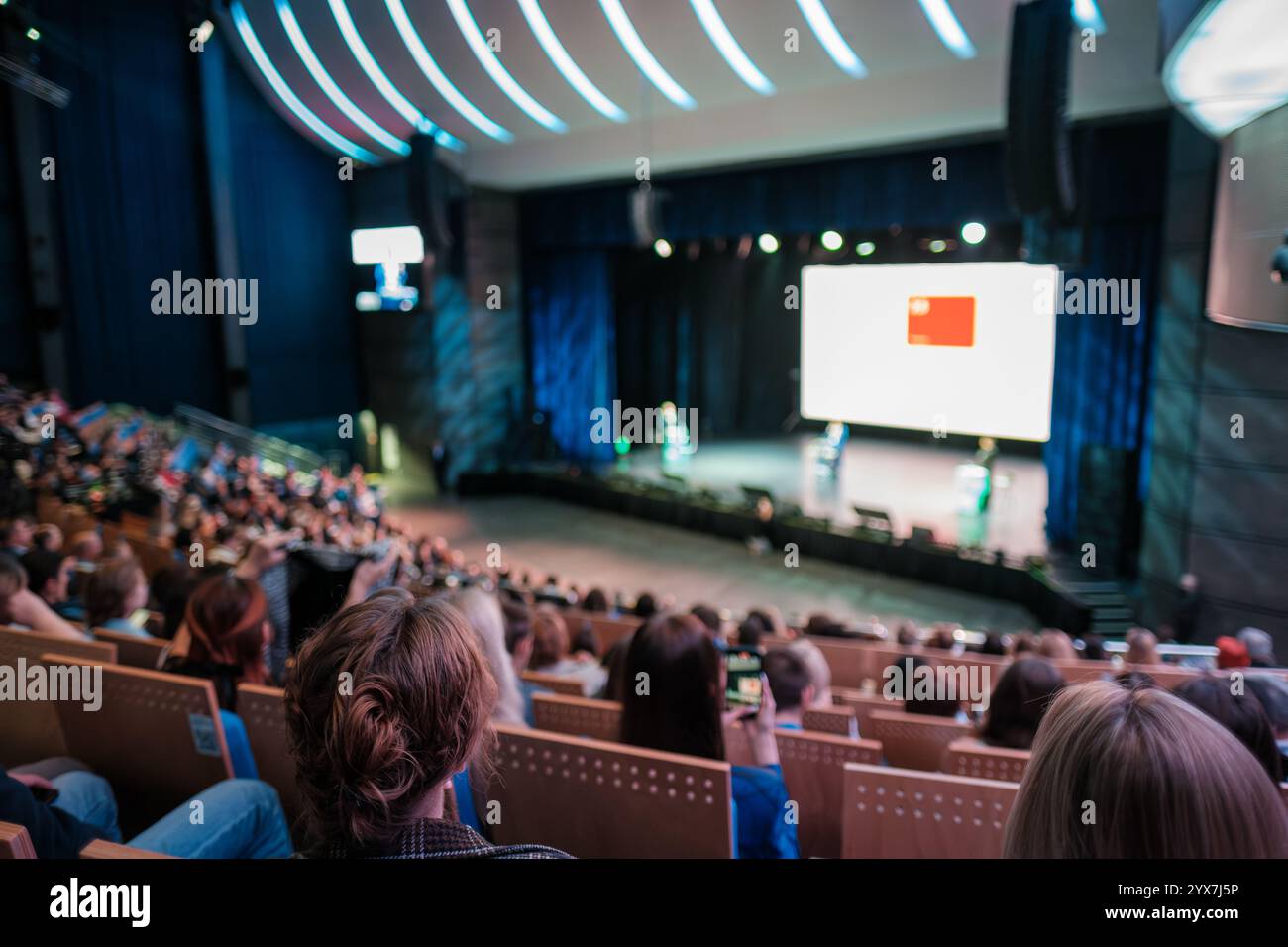 Snapshot of attendees listening to a presenter in a large seminar at an ...