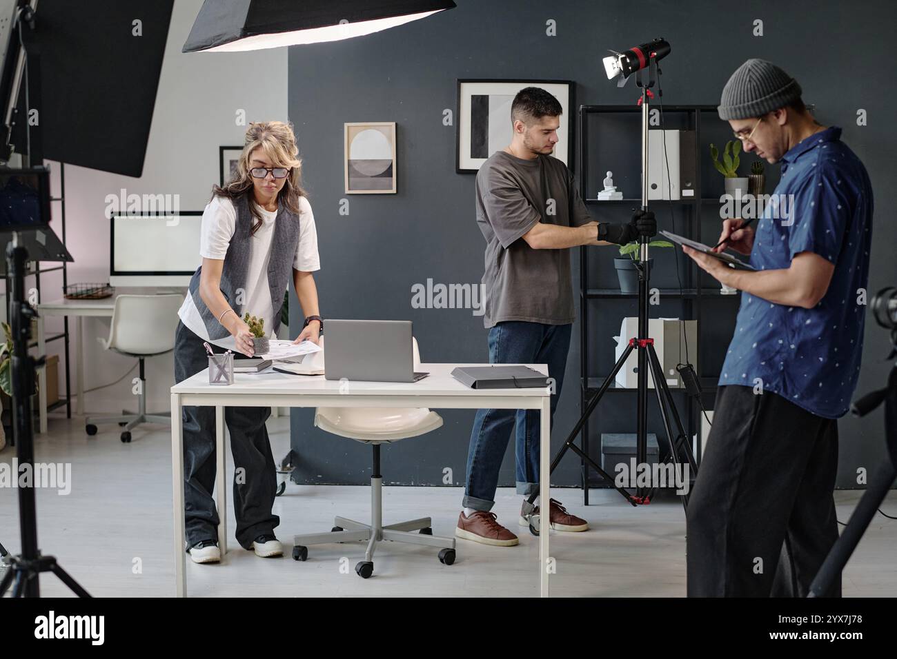 Female assistant decorating table with props while her male colleagues ...