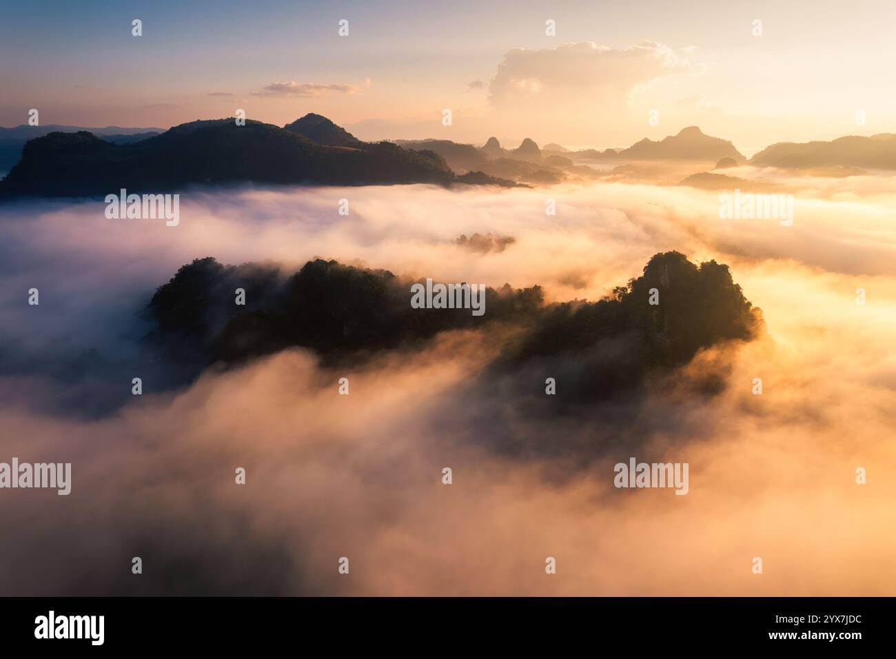 Aerial view of golden sunrise over foggy covered mountain in valley at ...