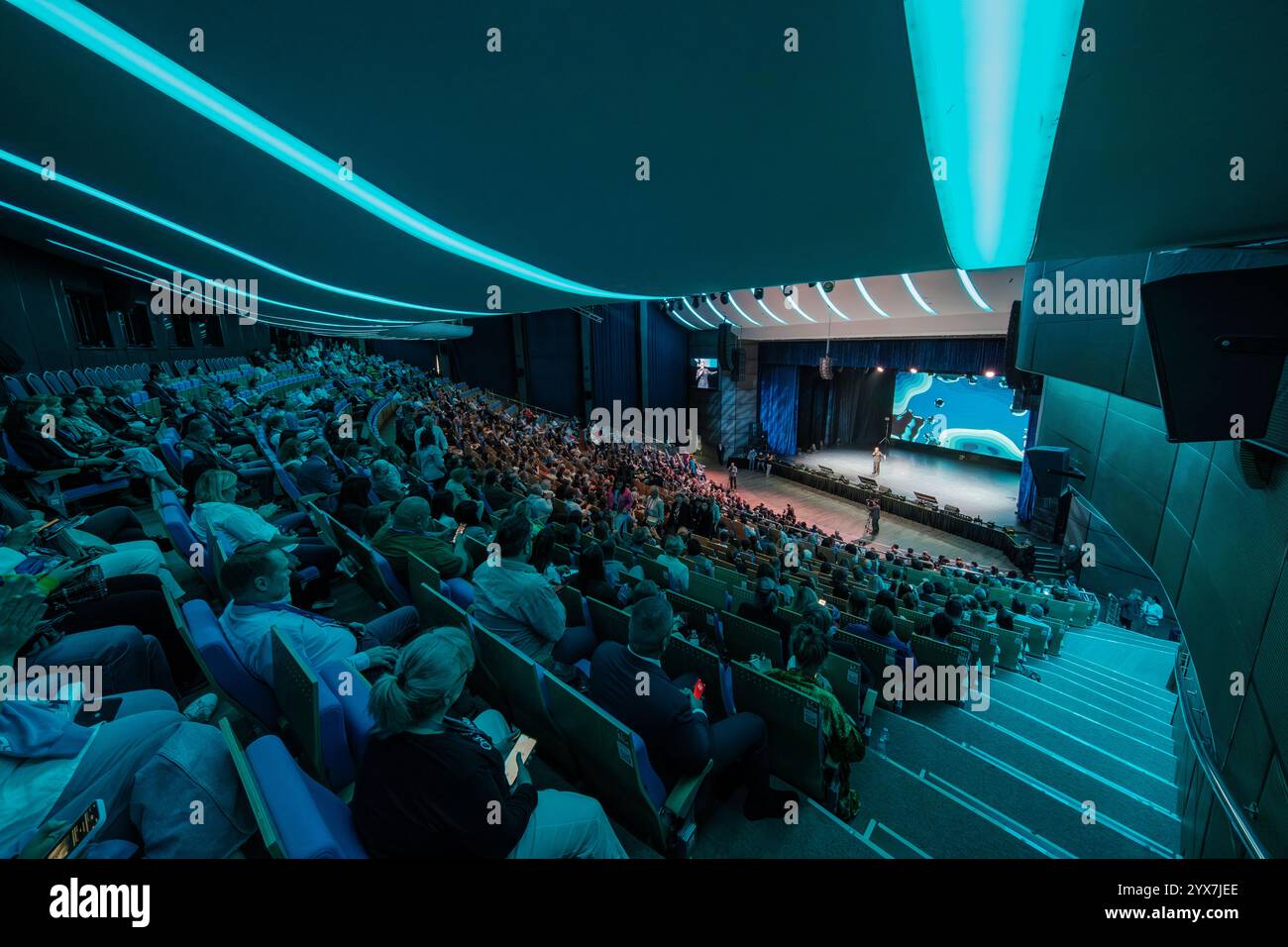 Modern theater auditorium filled with attendees observing a ...