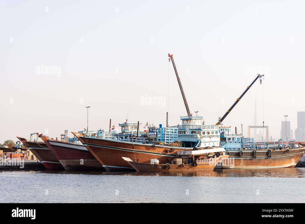 A row of traditional wooden boats docked at a port in Riggat Al Buteen ...