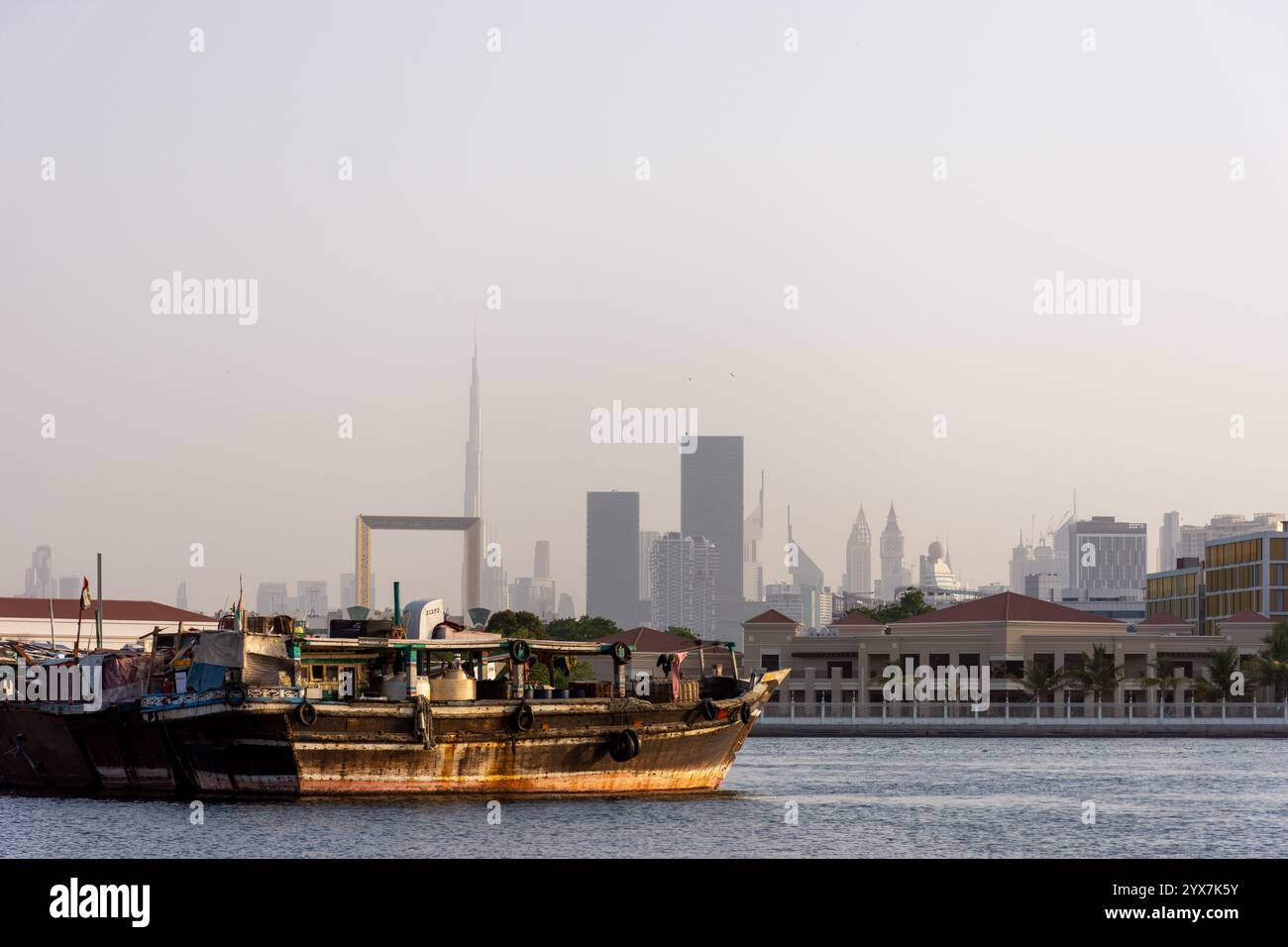 A traditional wooden cargo ship docked at a port in Riggat Al Buteen in ...