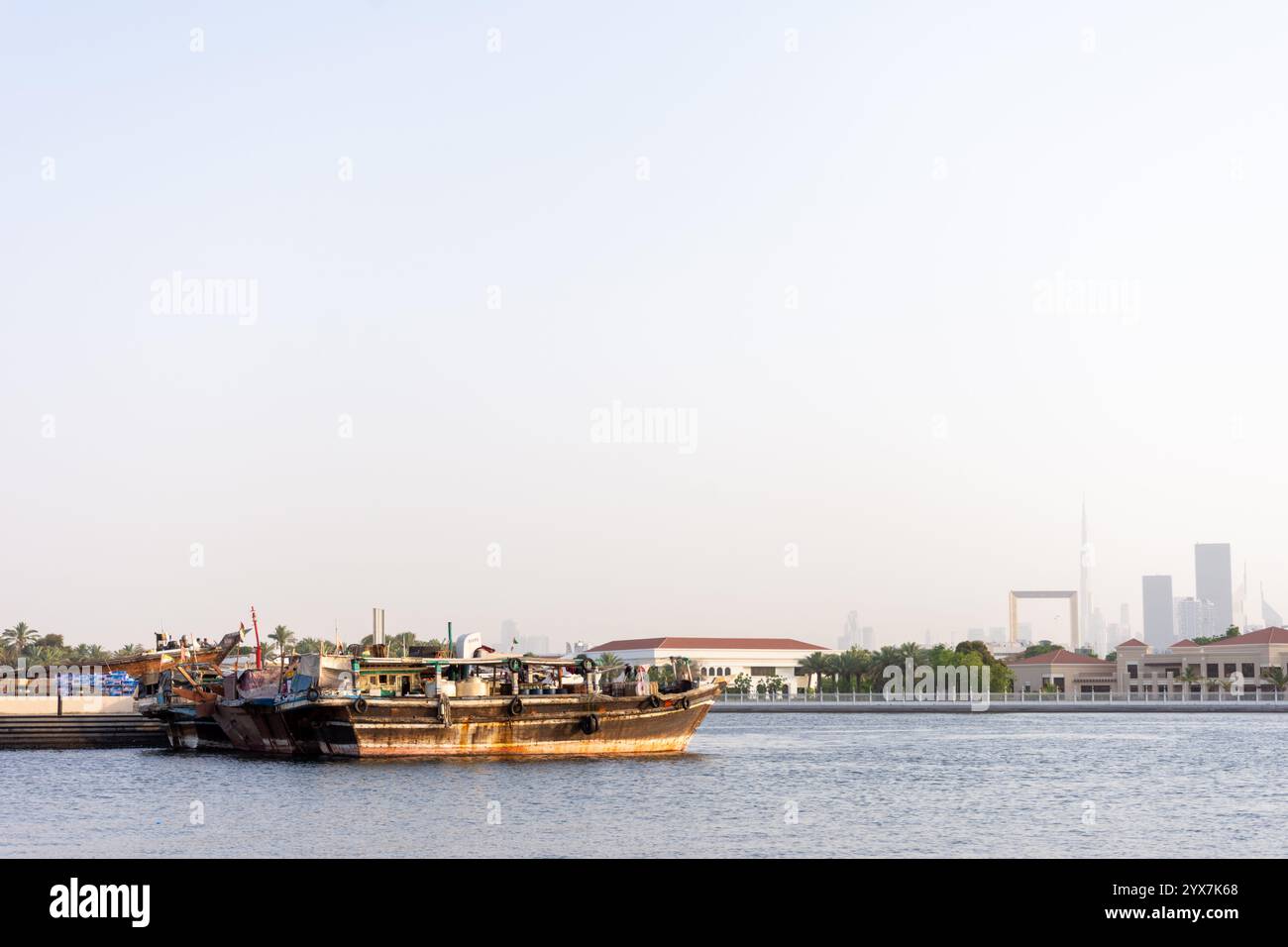 A traditional wooden cargo ship docked at a port in Riggat Al Buteen in ...