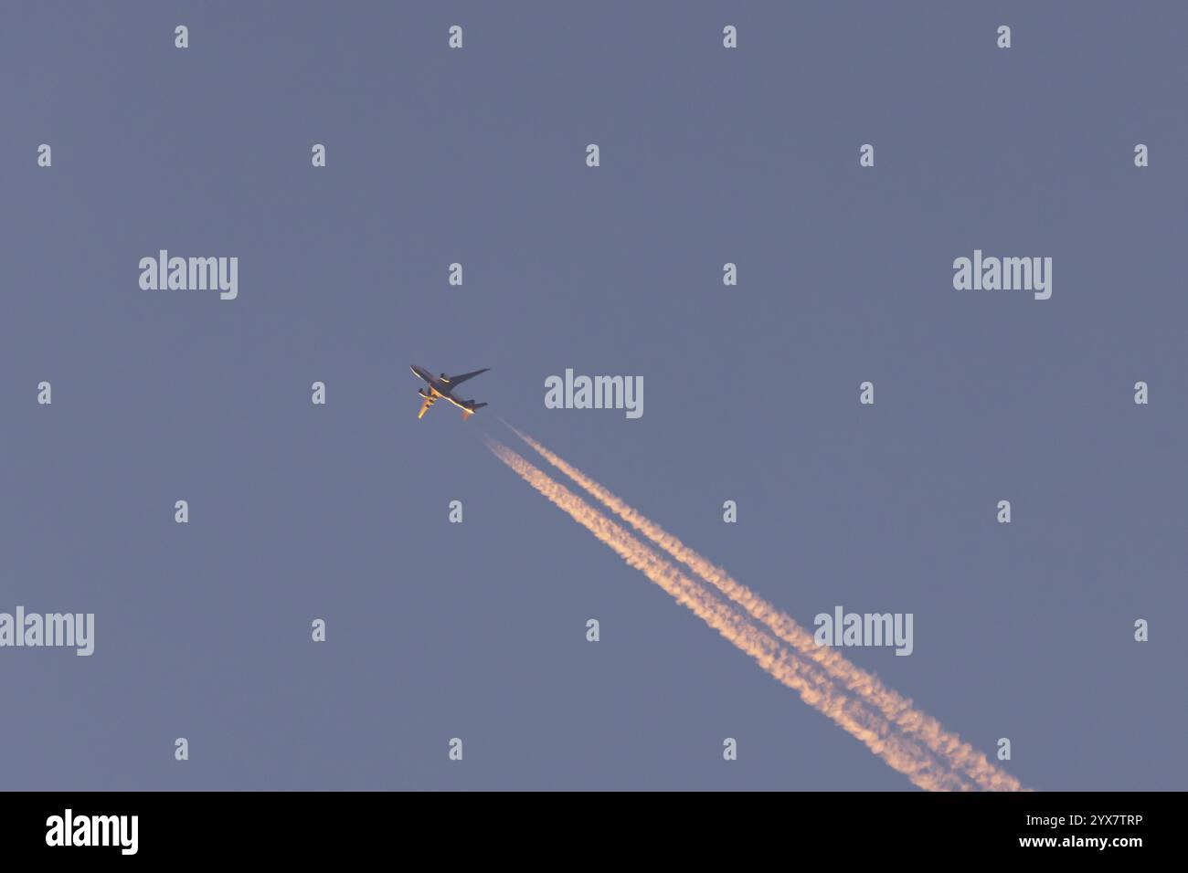 Boeing 767 jet cargo aircraft of FedEx flying in a blue sky with vapor ...