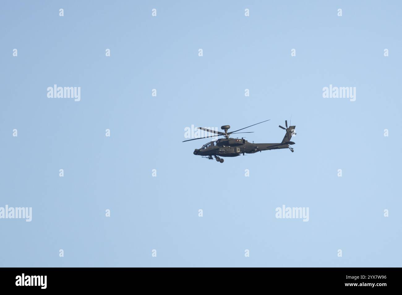 Boeing AH-64 Apache helicopter flying in a blue sky, England, United ...