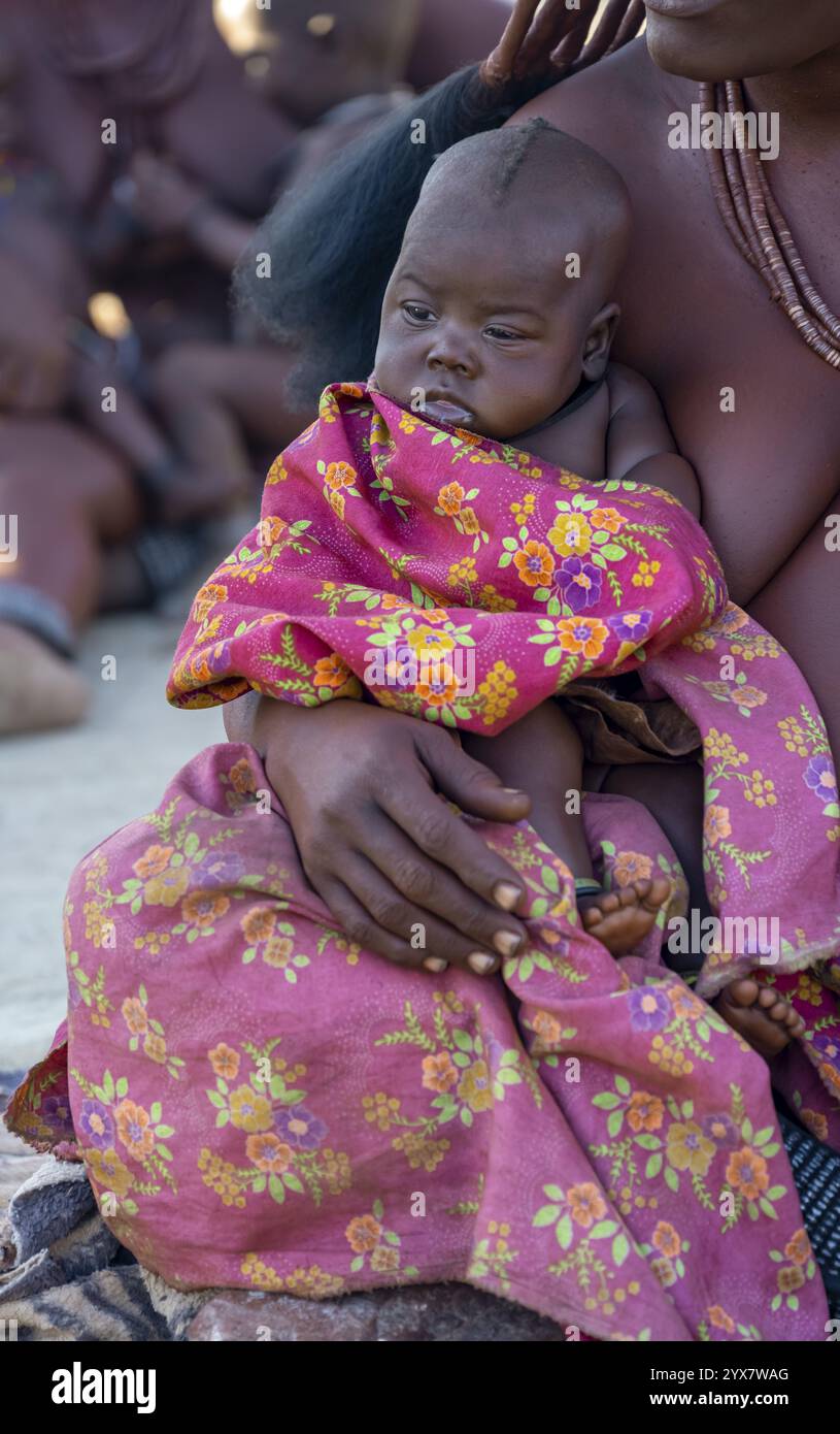 Baby in the arms of a Himba woman, traditional Himba village, Kaokoveld ...