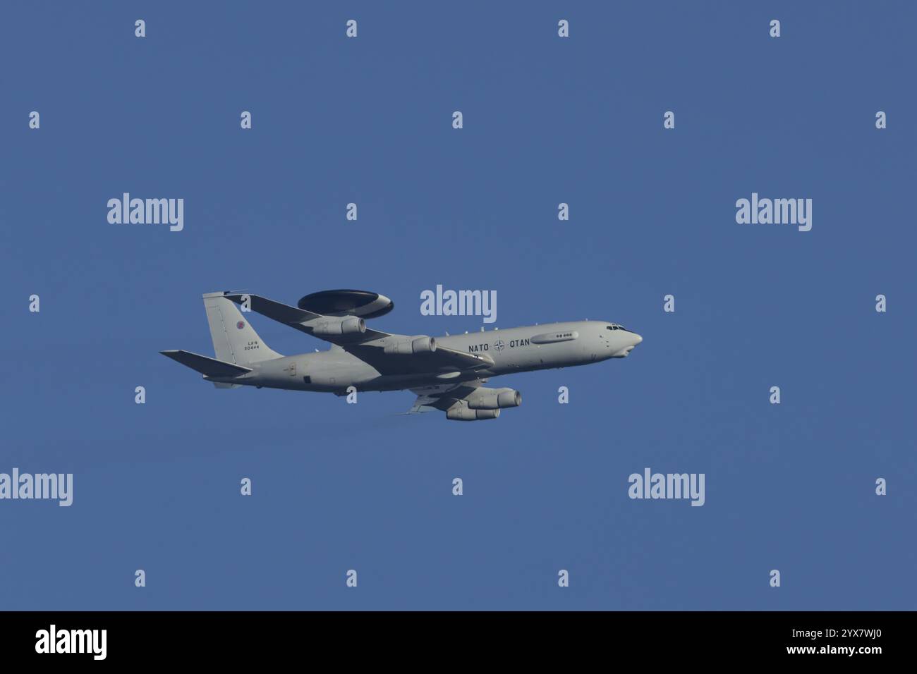 Boeing E-3 Sentry AWACS military aircraft of NATO flying in a blue sky, England, United Kingdom ...