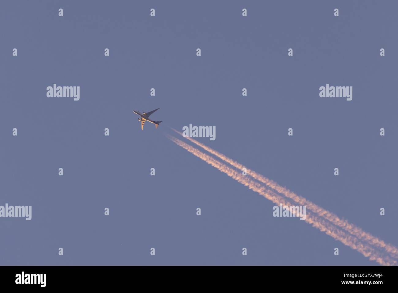 Boeing 767 jet cargo aircraft of FedEx flying in a blue sky with vapor ...