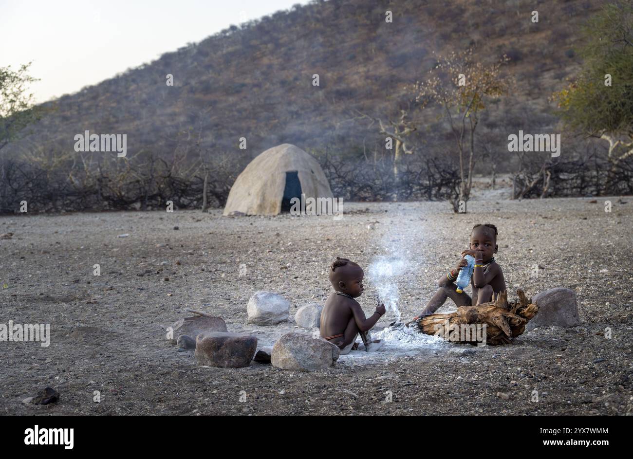 Himba children at an early morning fire, traditional Himba village ...