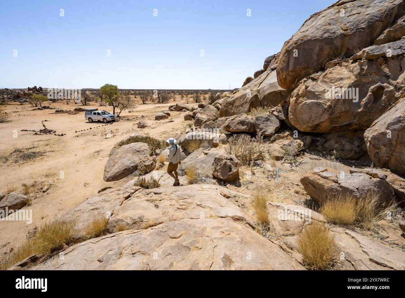 Young man between hills with round smooth rocks, Damaraland, Kunene ...