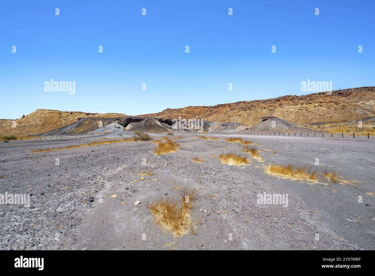 Dry landscape with yellow grass and black volcanic hills, Burnt ...