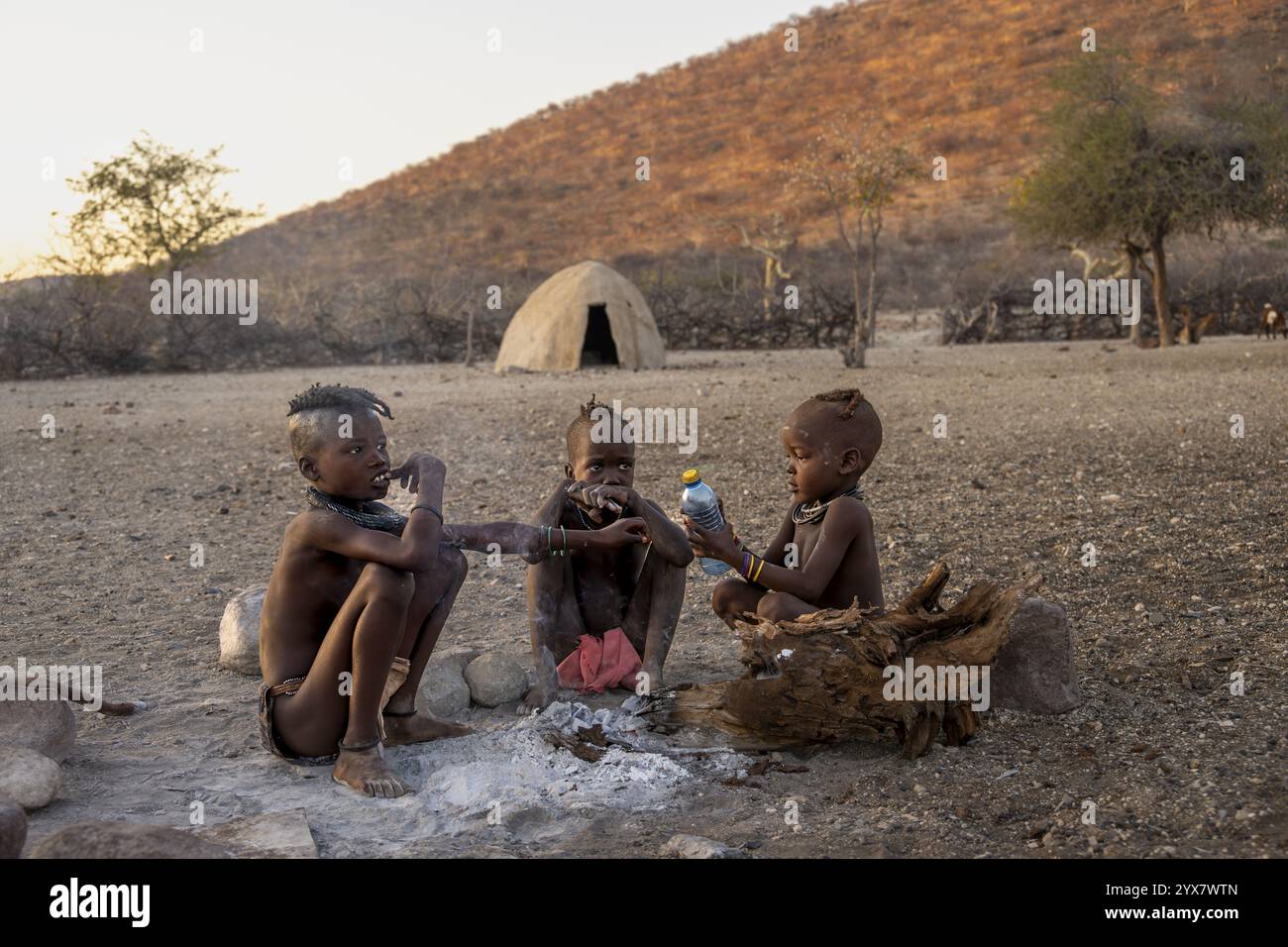 Himba children at an early morning fire, traditional Himba village ...