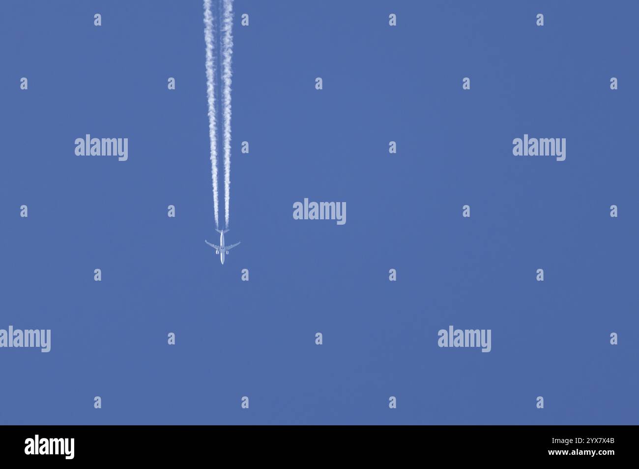 Airbus jet passenger aircraft flying in a blue sky with a vapor trail ...