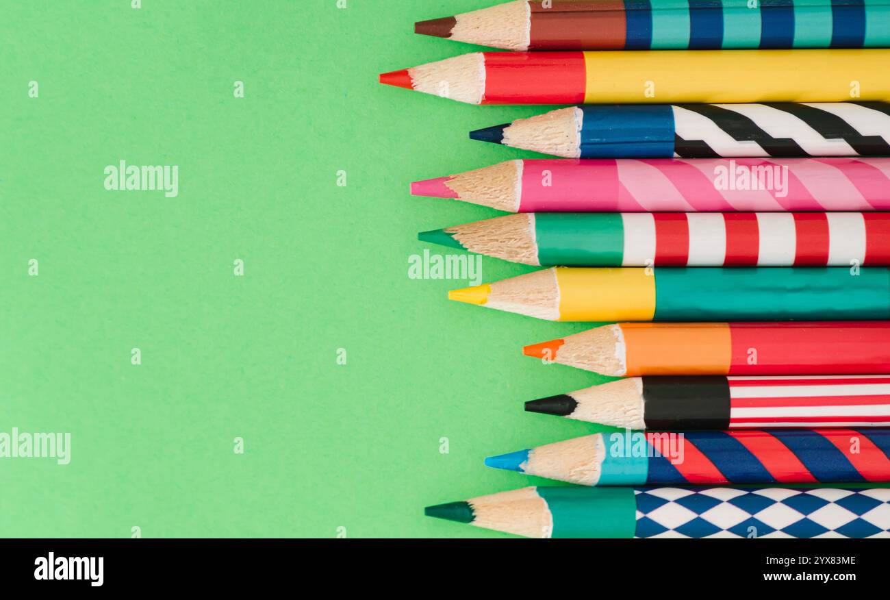 Creative layout made of colored pencils on pastel green background ...