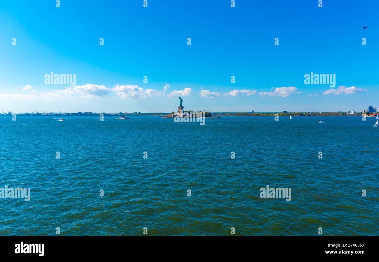 Statue of Liberty seen from the water under a blue sky. New York City ...