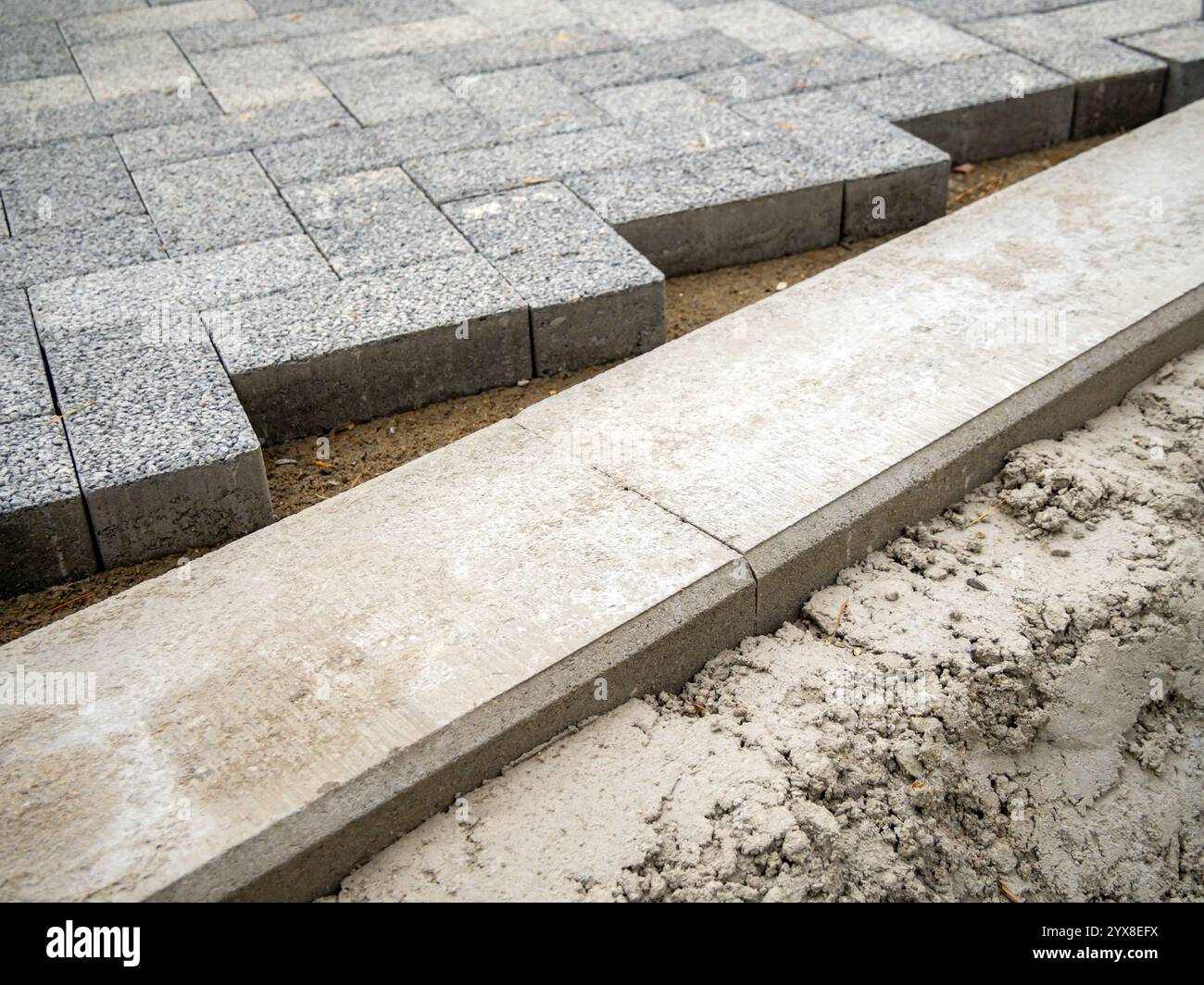 Laying curbstone flat when constructing a sidewalk Stock Photo - Alamy