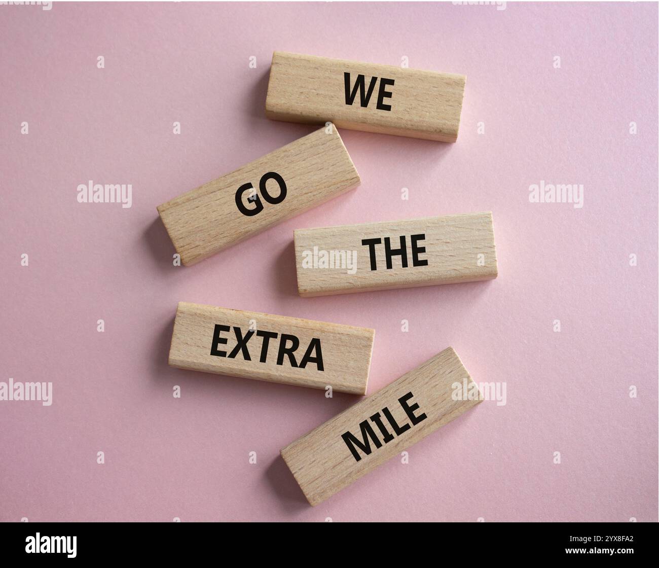 We go the extra mile symbol. Wooden blocks with words We go the extra ...