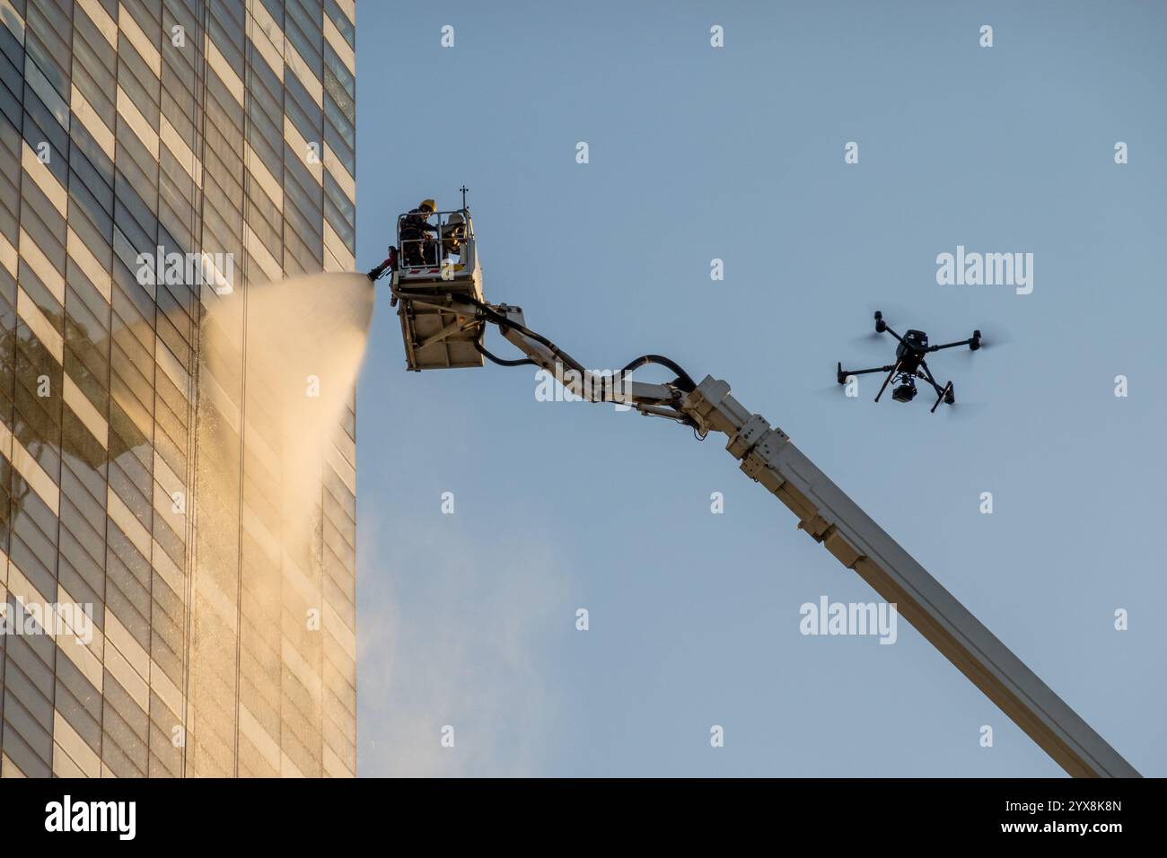 Drone monitoring firemen spraying water during fire fighting exercise ...