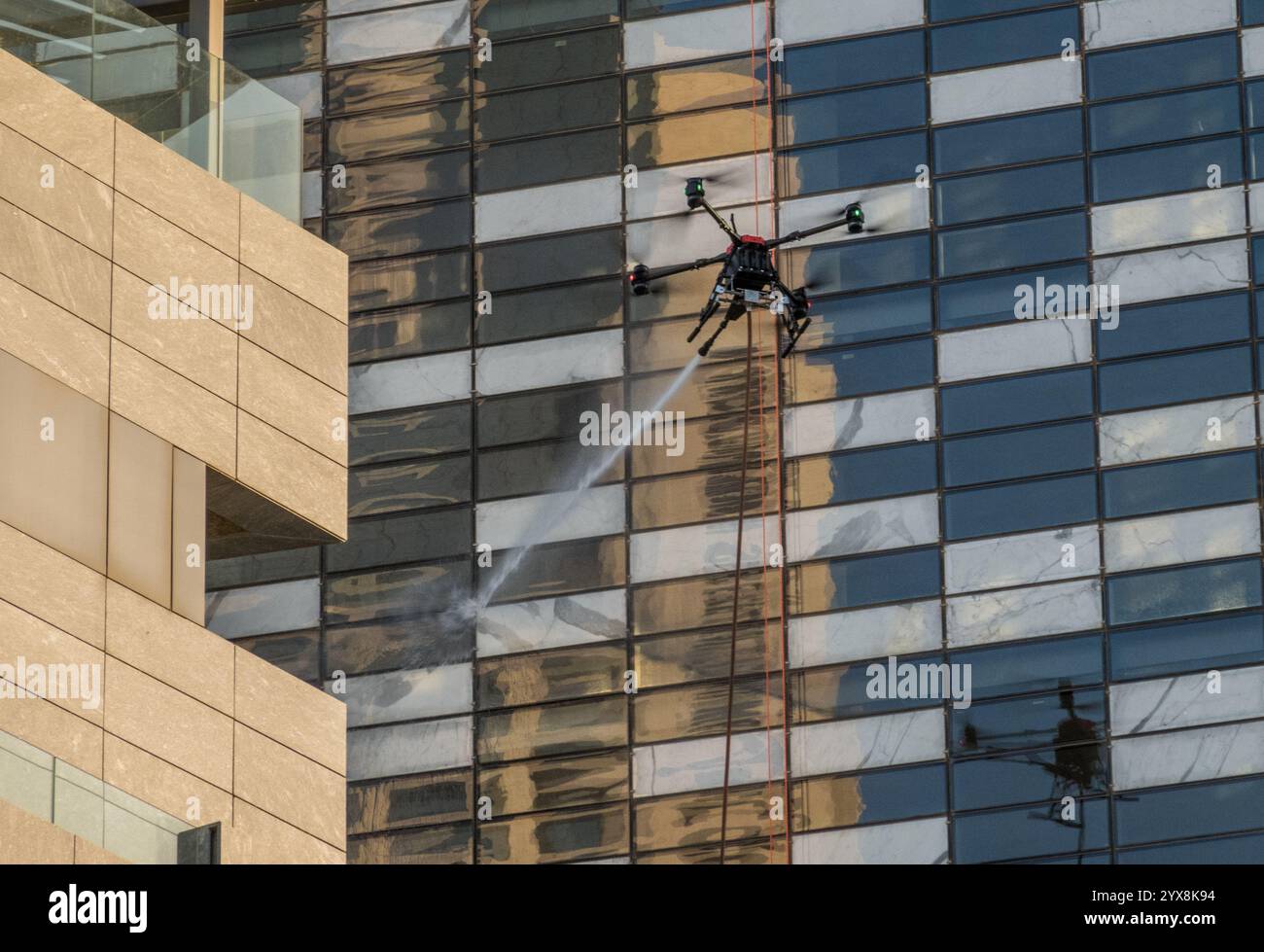 Drone spraying water during fire fighting emergency exercise on modern ...
