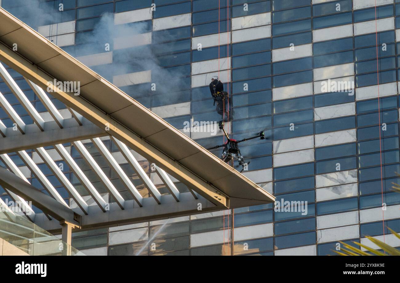 Drone spraying water during fire fighting emergency exercise on modern ...