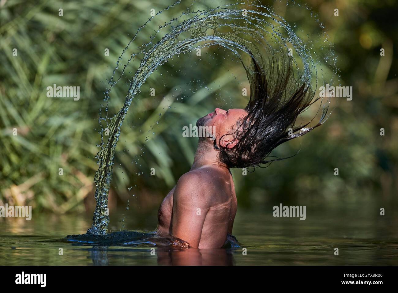 Man whipping wet hair in the lake Stock Photo - Alamy