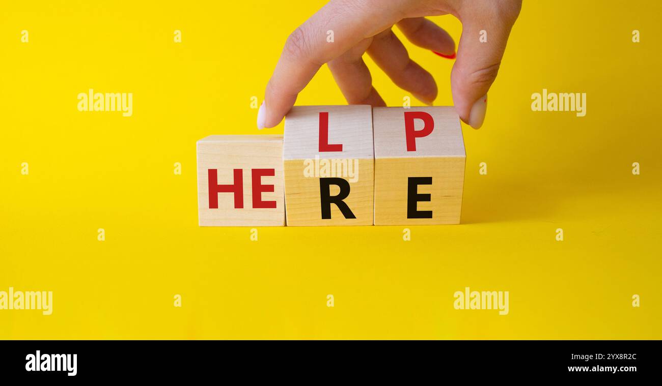Help is here symbol. Businessman hand Turns cube and changes word Here ...